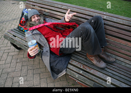 Crazy and happy homeless wanderer sitting on bench outside Stock Photo ...