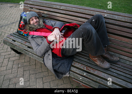 Crazy and happy homeless wanderer sitting on bench outside Stock Photo ...