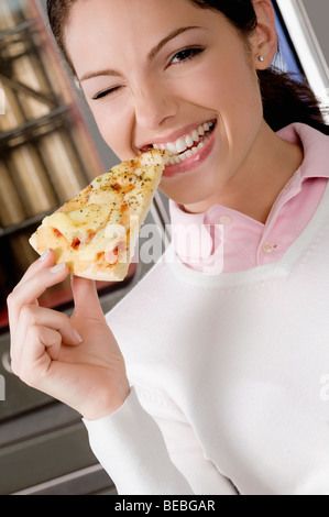 Female chef eating a pizza and winking Stock Photo - Alamy
