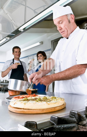 Latin chef cook pizza in industry professional kitchen oven. venezuelan ...