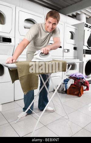 Hispanic man holding electric iron smiling with a happy and cool smile ...
