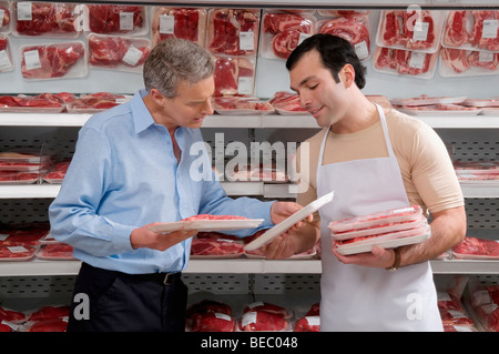 Customer selecting packaged meat in refrigerated section of a Albert ...