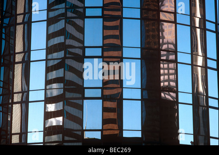 Abstract reflections of buildings in the curved green glass façade of ...