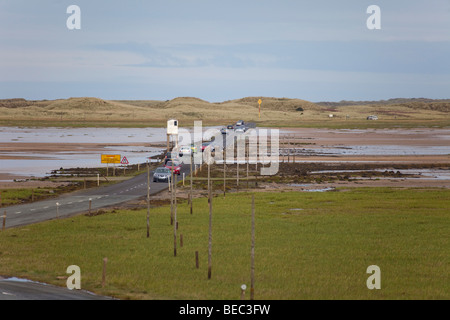 Causeway tide road path with cars at Lindisfarne Holy Island UK ...