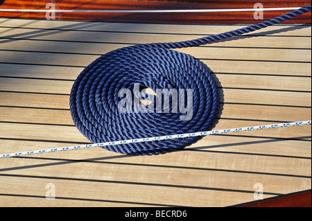 Coiled rope on teak deck. Decorative coiling is called 'cheesing' or ...