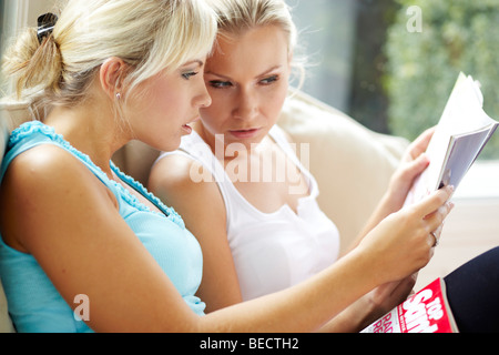 Two girls reading magazines Stock Photo - Alamy