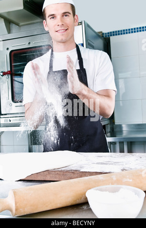 The chef cleaning the pizza oven. Raw pizza ready to bake. Cook in a ...