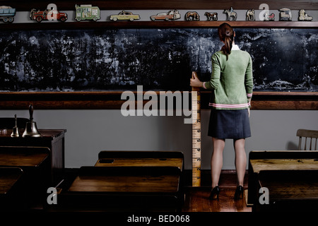 Female teacher holding a ruler in a classroom Stock Photo - Alamy
