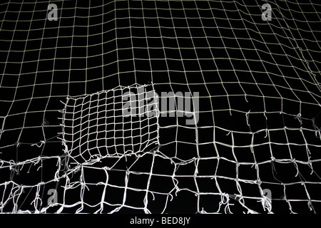 Close-up of a DIY soccer goal made of white PVC pipes with a worn net ...