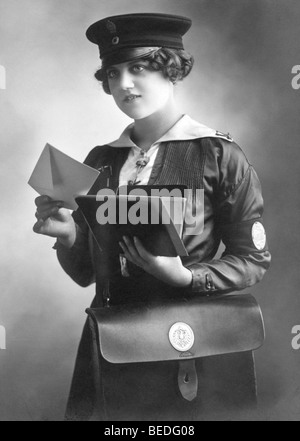A black-and-white photograph of a letter carrier with a two-wheeled ...