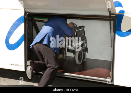 driver Loading luggage into luggage hold of a coach Stock Photo - Alamy