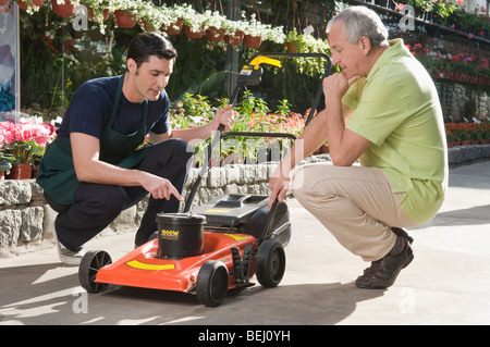 Man explaining about a lawn mower to a customer Stock Photo - Alamy