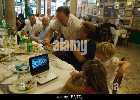 Child watching computer laptop screen while mother works at night Stock ...