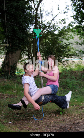 Teenagers having fun on a zip wire Stock Photo - Alamy