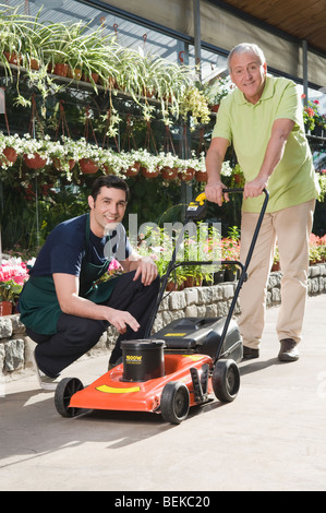 Man explaining about a lawn mower to a customer Stock Photo - Alamy