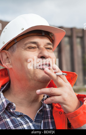 Construction worker smoking Stock Photo - Alamy