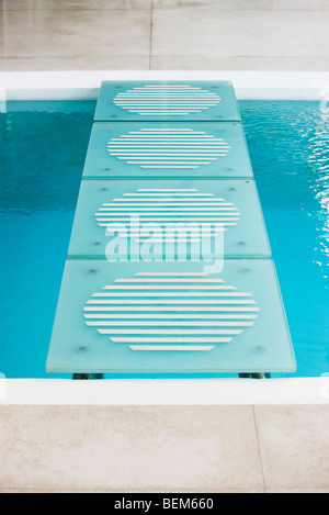 Stepping stones leading across swimming pool Stock Photo - Alamy