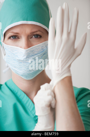 Mature woman putting in contact lenses on brown background Stock Photo ...