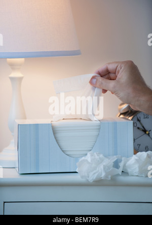Hand pulling tissue out of box Stock Photo - Alamy