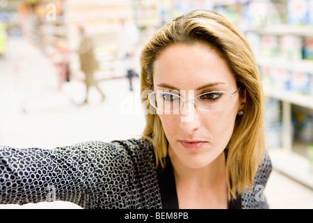 Woman in casual clothes came to the supermarket for cleaning products ...