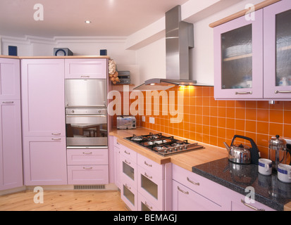 Mauve fitted units in modern open-plan kitchen with stainless-steel ...