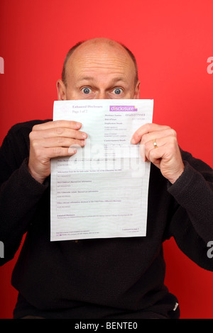 Man holds up a clean CRB Enhanced Disclosure form Stock Photo - Alamy
