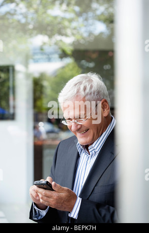 Happy Senior Businessman Using Phone In The Office Stock Photo - Alamy