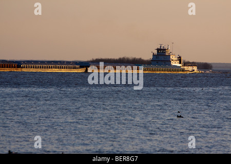 Pushing a few barges north along the Mississippi River, a large tug ...