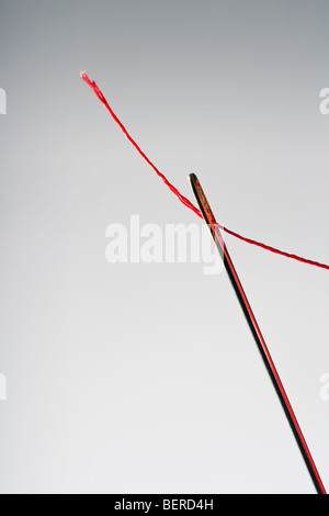 macro image of needle and red thread against colorful background Stock ...