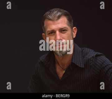 Handsome middle-aged man on grey background looking at camera. with ...