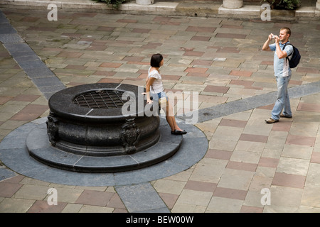 Boy looking into wishing well Stock Photo - Alamy