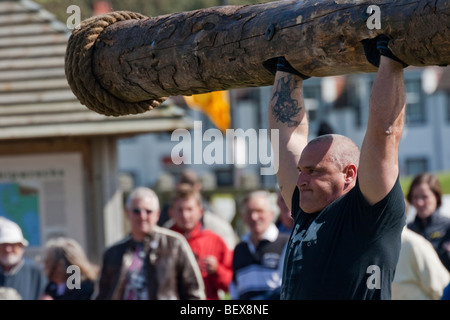 Strongman lifting log at Galloway Gathering Stock Photo - Alamy