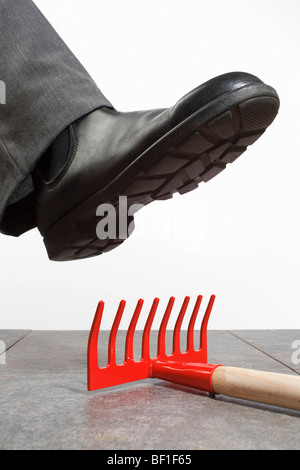 Human foot stepping on a rake Stock Photo - Alamy