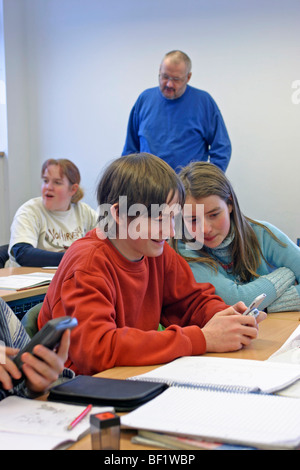 Student using Mobile Phones at the desk Stock Photo - Alamy