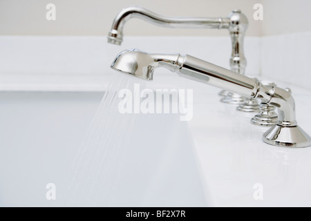 Water running from shower tap fitting in outdoor shower with wooden ...