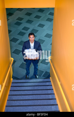 Man office worker holding stack of binders with lots of documents work ...