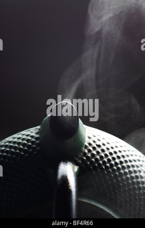 A top view of a cast iron teapot and a tea cup, mug set on a wooden ...