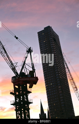 A red tower crane seen against the background of the sky in central ...