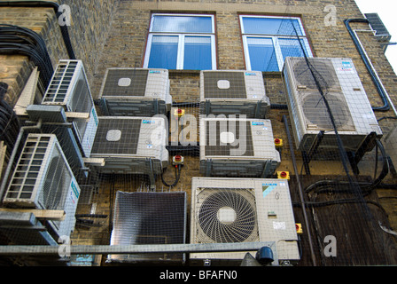 air conditioning machine fans on an exterior wall in a back street of ...