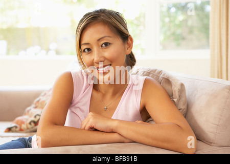 Young woman relaxing on sofa at home Stock Photo - Alamy