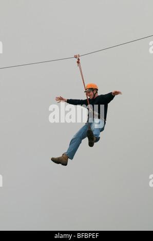 man sliding down rope in forest Stock Photo - Alamy