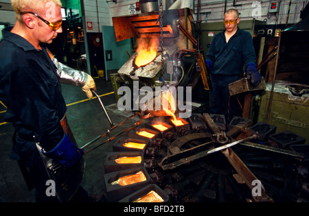 Industry. Mining. Gold Smelting. Workers pouring molten gold metal ...