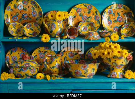 Collection of colourful Mary Rose Young pottery on turquoise dresser ...