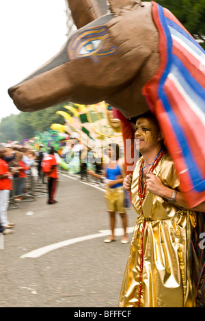 Man wearing a gold costume and carrying a large dog/wolf head piece at ...