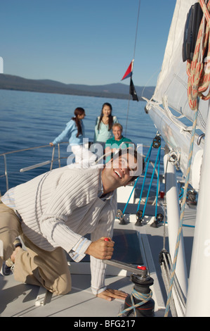 Raising the sail on a yacht. Young man captan lifting the sail of ...