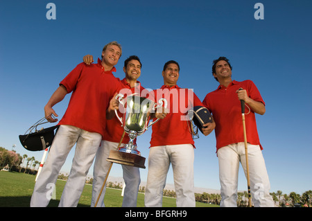 Four polo players with trophy Stock Photo - Alamy