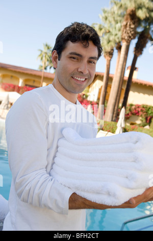 Portrait of man carrying towels at health spa Stock Photo - Alamy