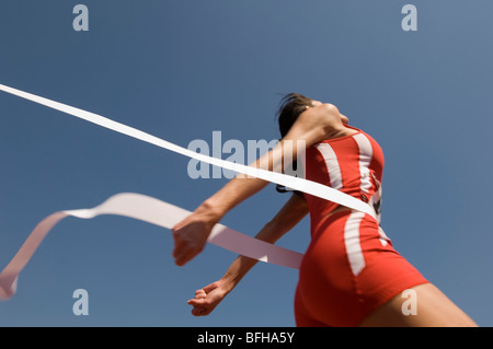 Female track athlete crossing finishing line Stock Photo - Alamy
