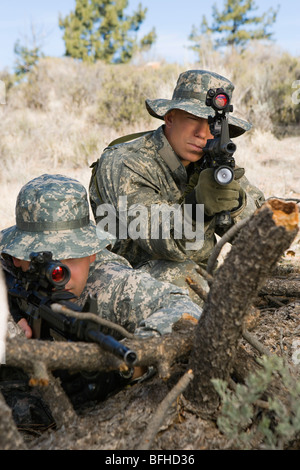 Soldiers aiming machine gun, leaning on log Stock Photo - Alamy
