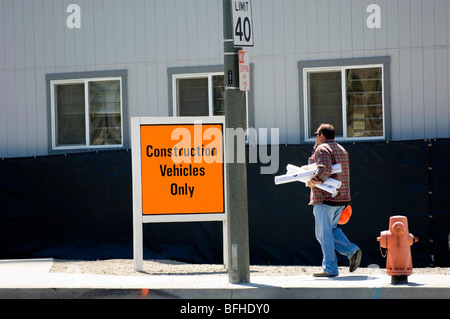 Engineer with drawings enters a construction area Stock Photo - Alamy
